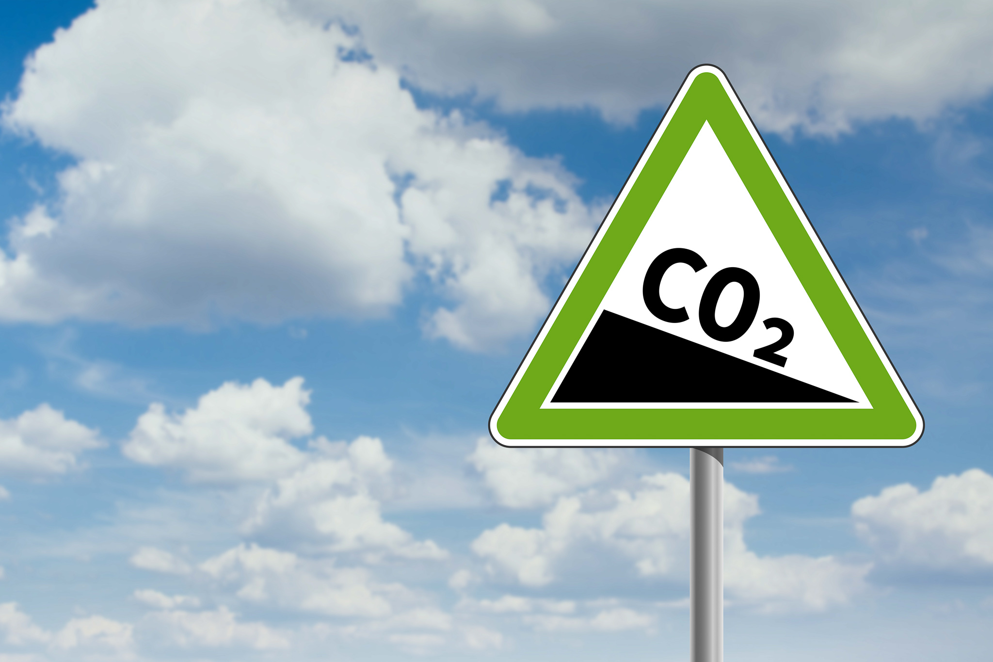 CO2 emission reduction sign green triangular shape blue sky - Aerodyne